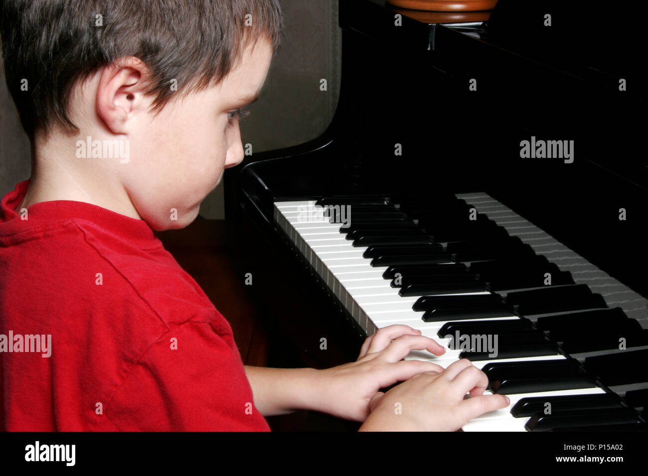 A young child concentrates while touching keys on the keyboard Stock ...