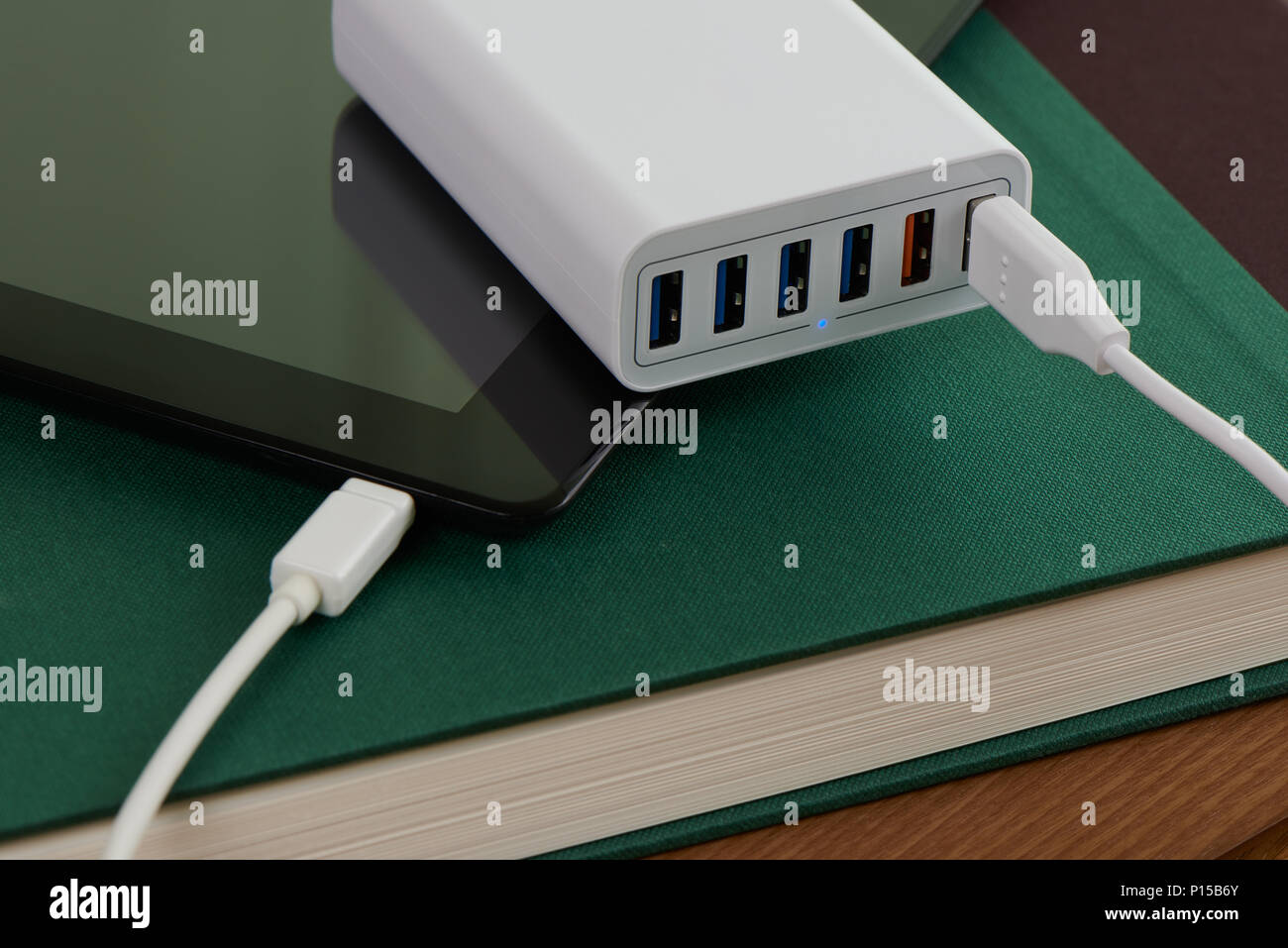 multiport charging station and charging tablet PC on a desk Stock Photo ...