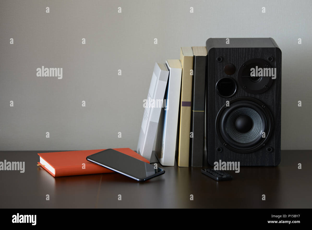 bookshelf speaker with books, smartphone and remote controller on a TV ...