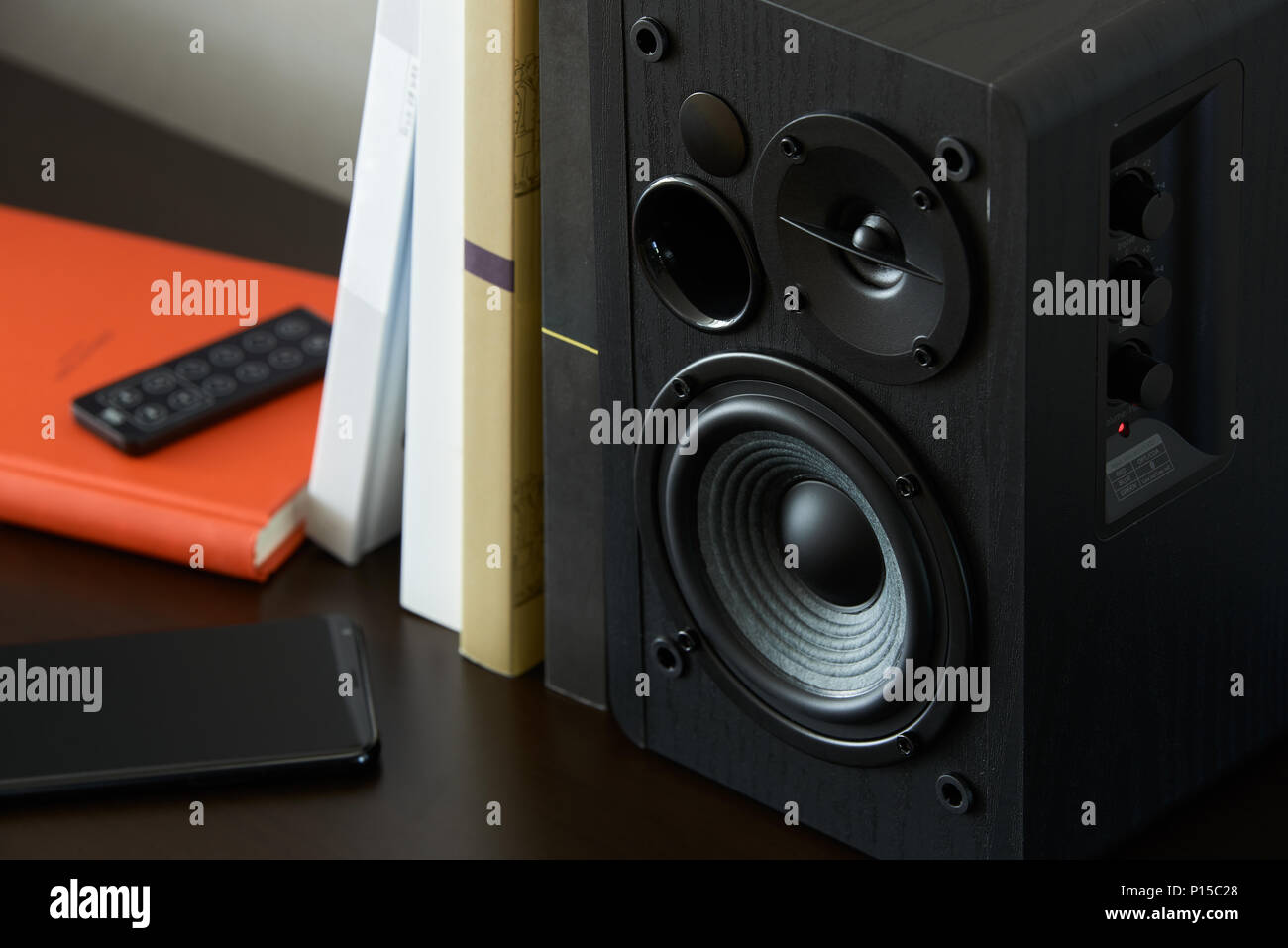 bookshelf speaker with books, smartphone and remote controller on a TV ...