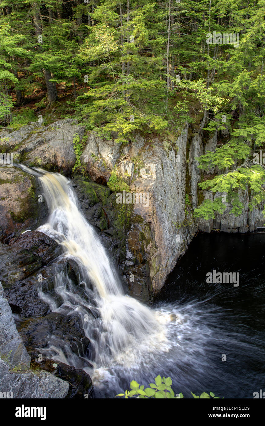 A beautiful waterfall flows down into a stream below Stock Photo - Alamy