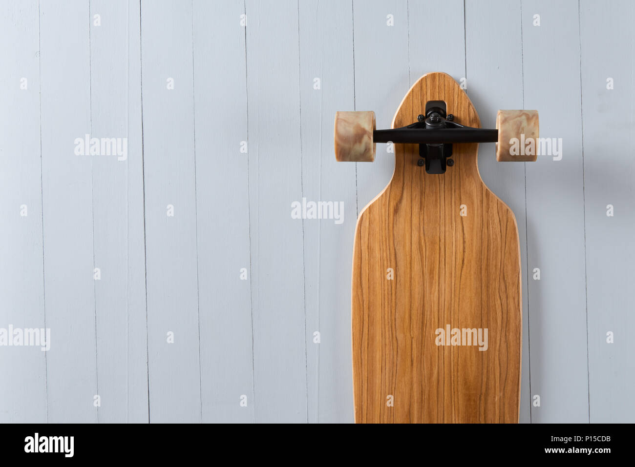 wood pattern bottom of pintail shaped longboard on a sky blue ...