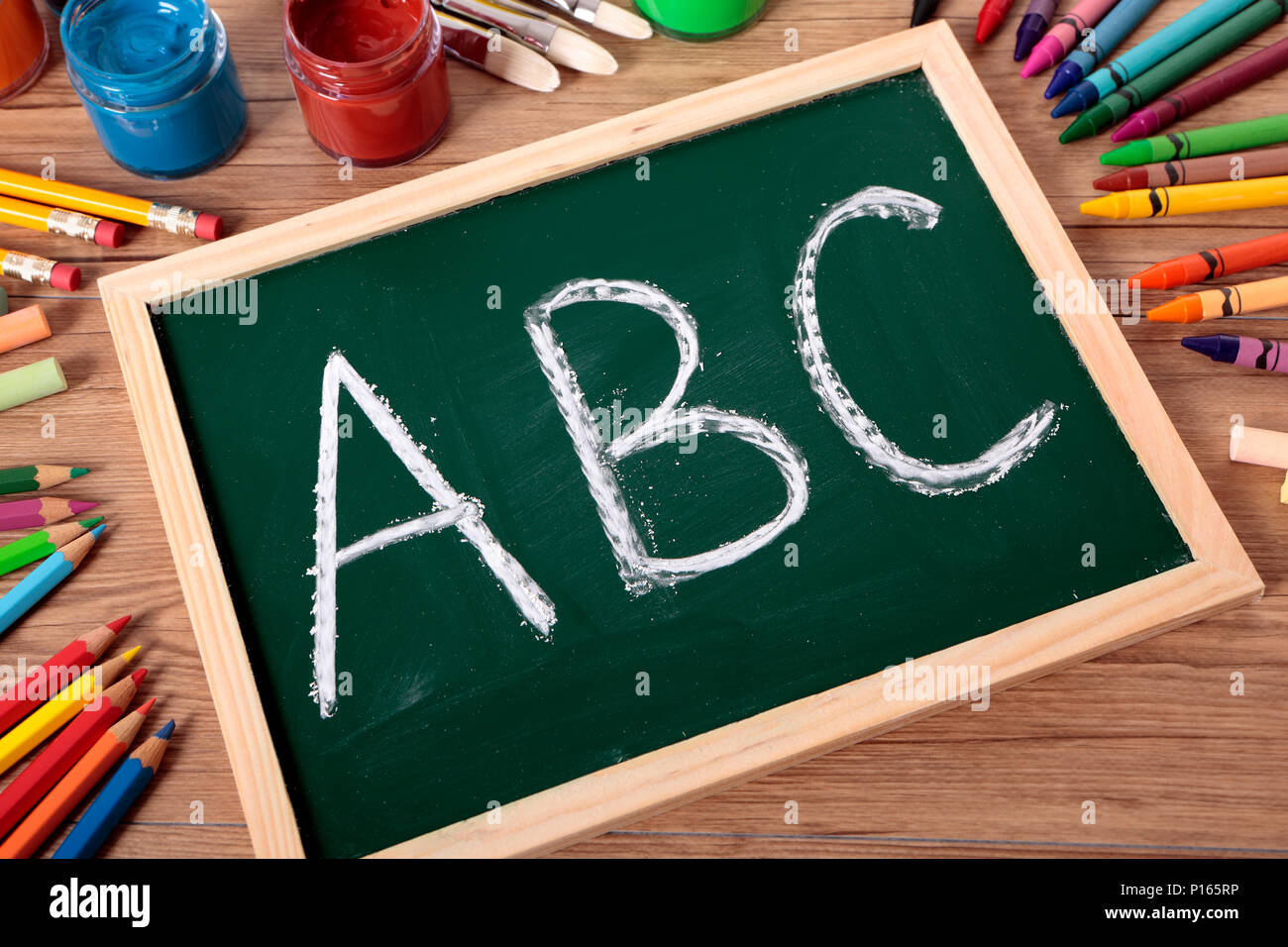 ABC written on a small elementary blackboard with various paints ...