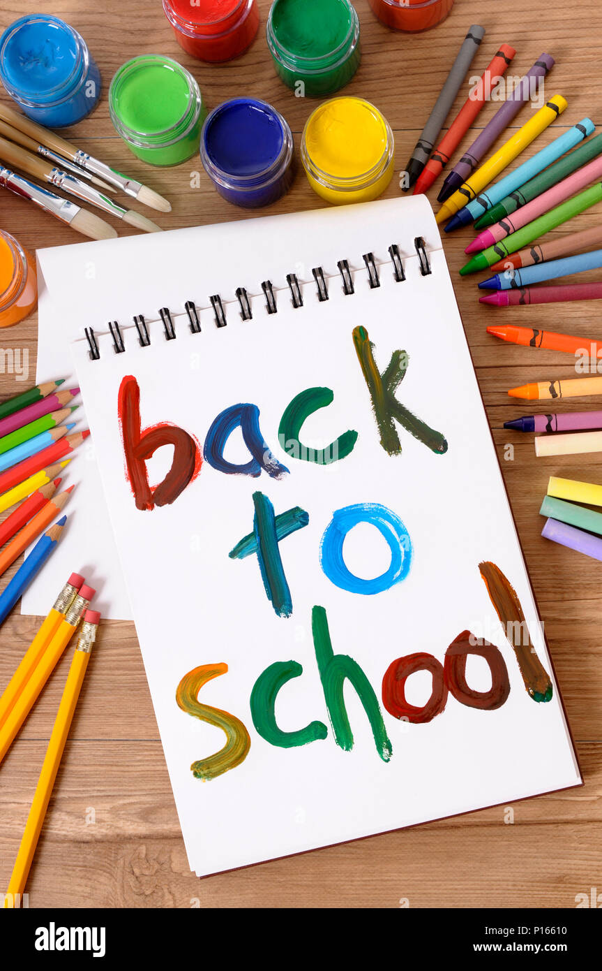 The words Back to School painted on a white art book with various ...