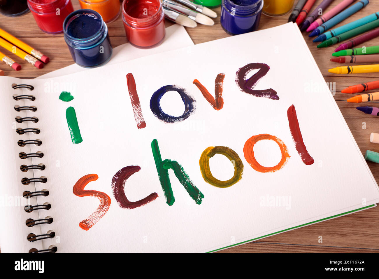 The words I Love School painted on a white art book with various paints ...