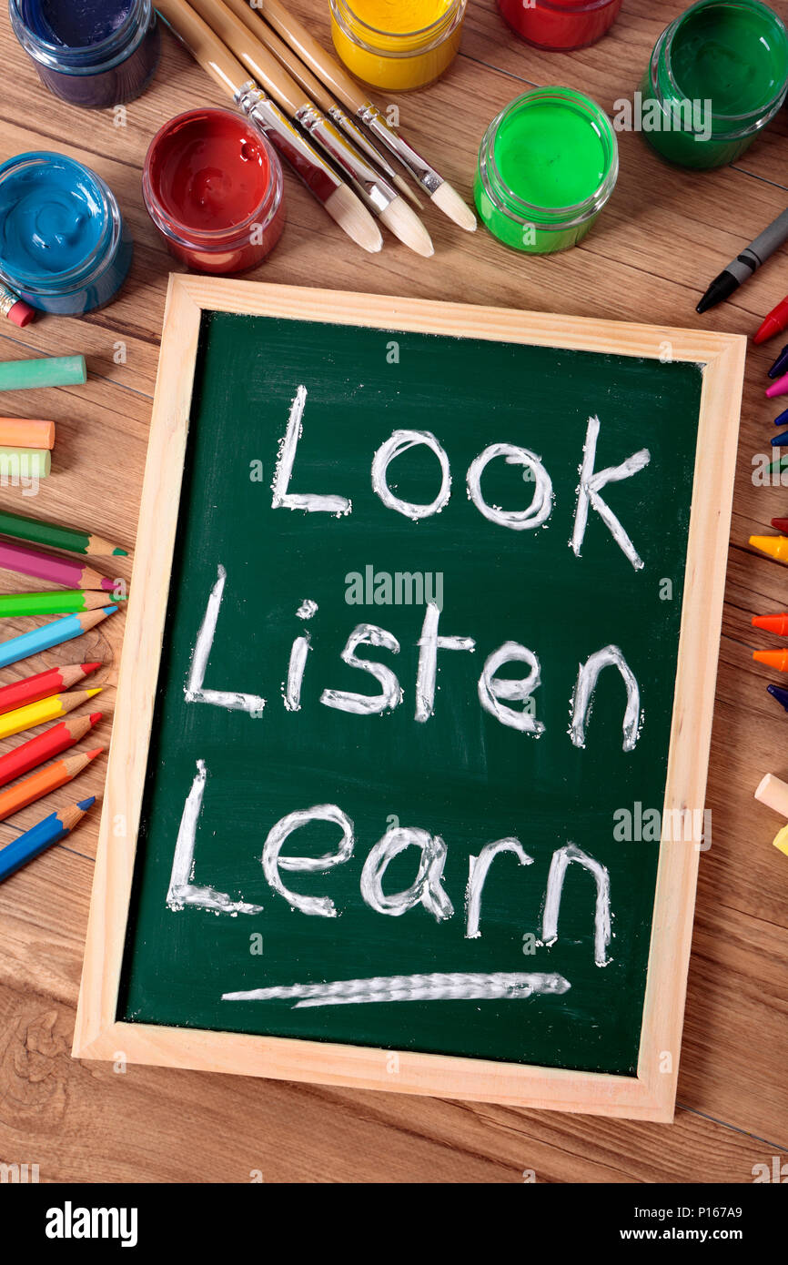 The words Look, Listen, Learn written on a small elementary blackboard ...