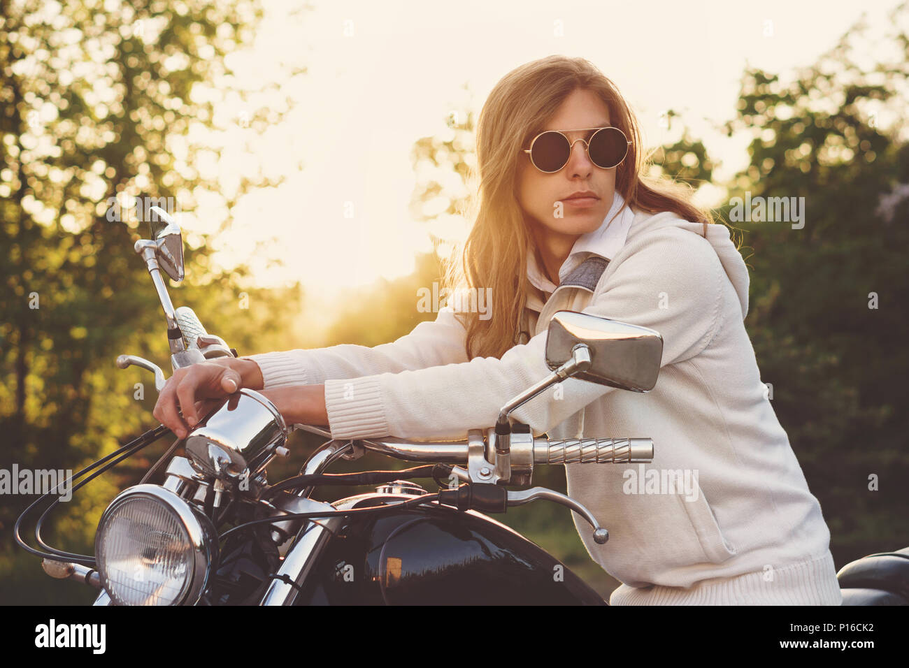 Biker wearing sunglasses and a jacket at wheel of a motorcycle. Guy ...
