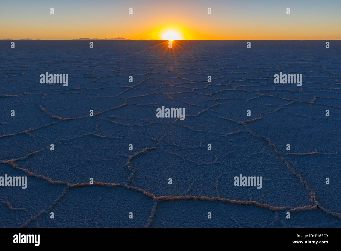 The last sun rays shining on the desert of salt in the Uyuni salt flat ...