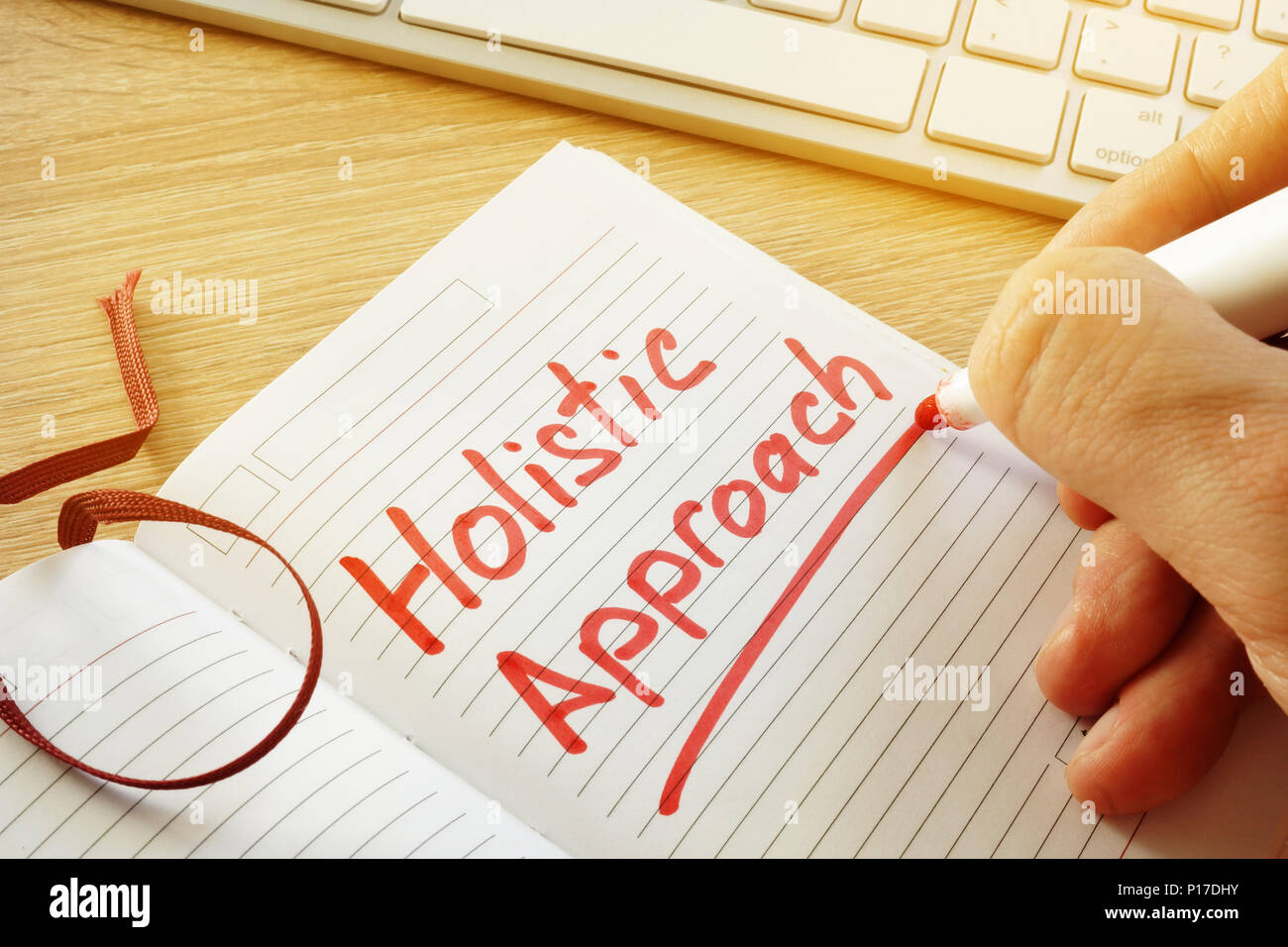 Hand is writing Holistic approach in the note Stock Photo - Alamy