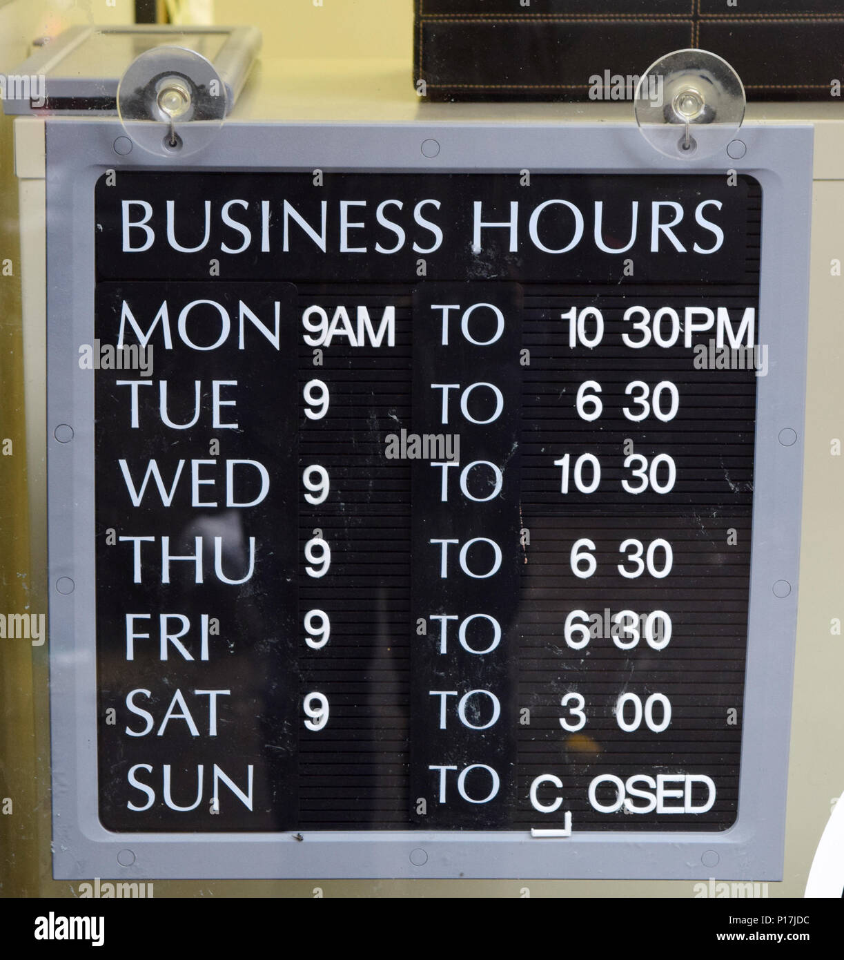 Sign showing business opening hours Stock Photo - Alamy