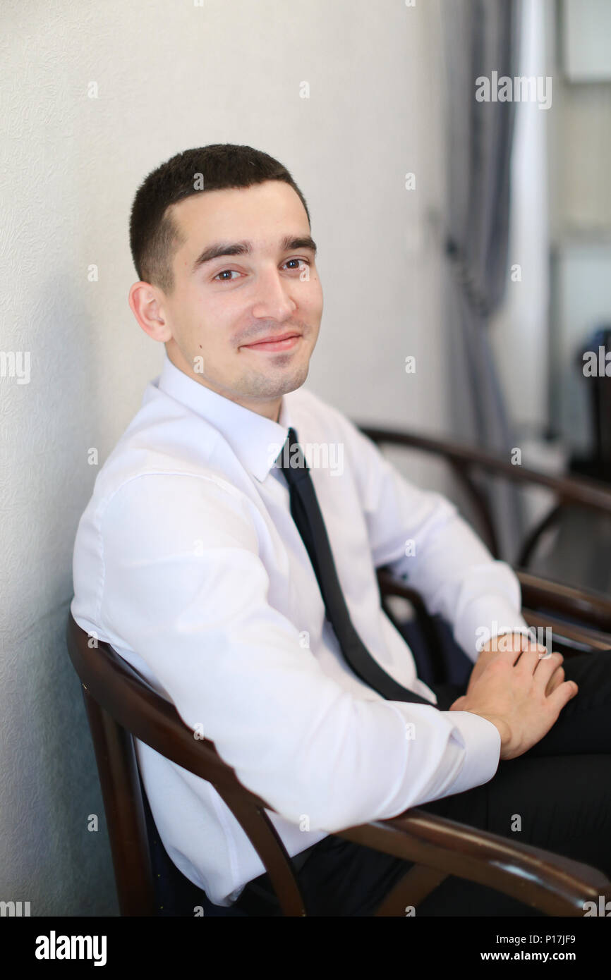 Young european businessman wearing white shirt with black tie sitting ...