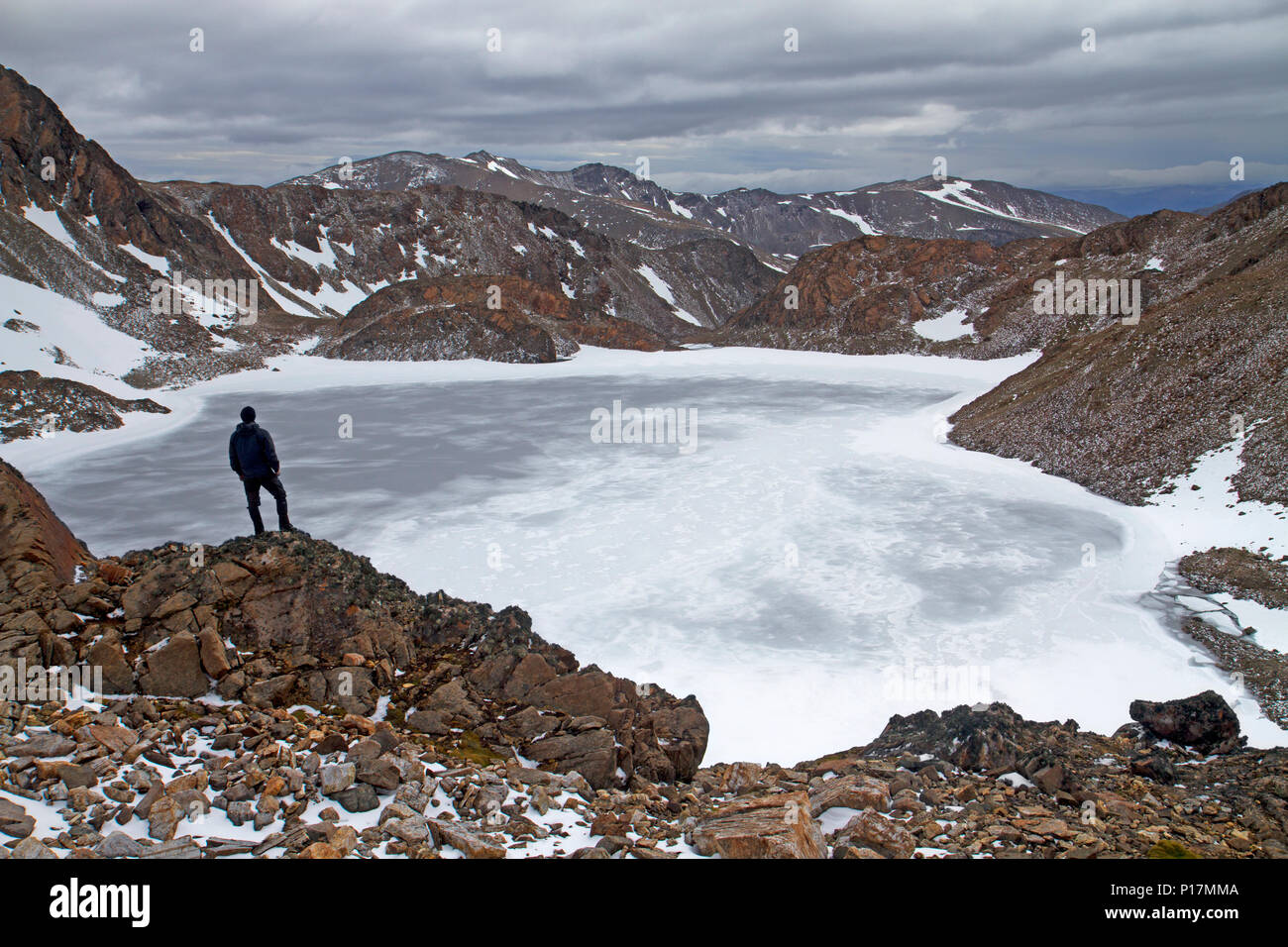 Hiker above a frozen Laguna del Paso along the Dientes Circuit, the ...