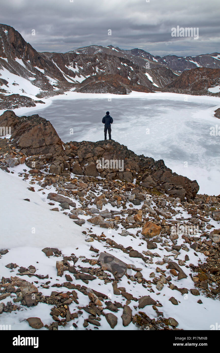 Hiker above a frozen Laguna del Paso along the Dientes Circuit, the ...