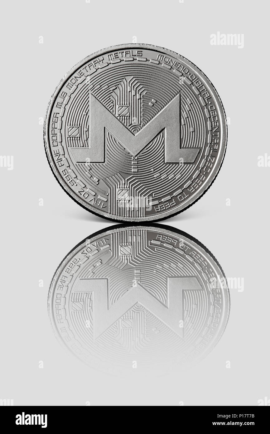 Silver coin monero on a white glossy background Stock Photo - Alamy