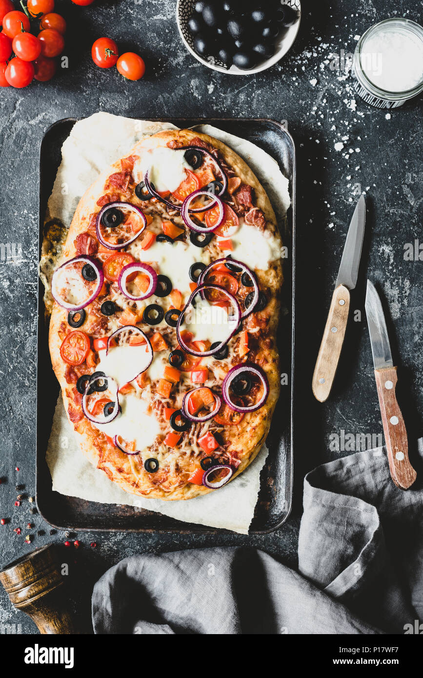 Flatbread pizza with mozzarella and black olives on wooden pizza board ...
