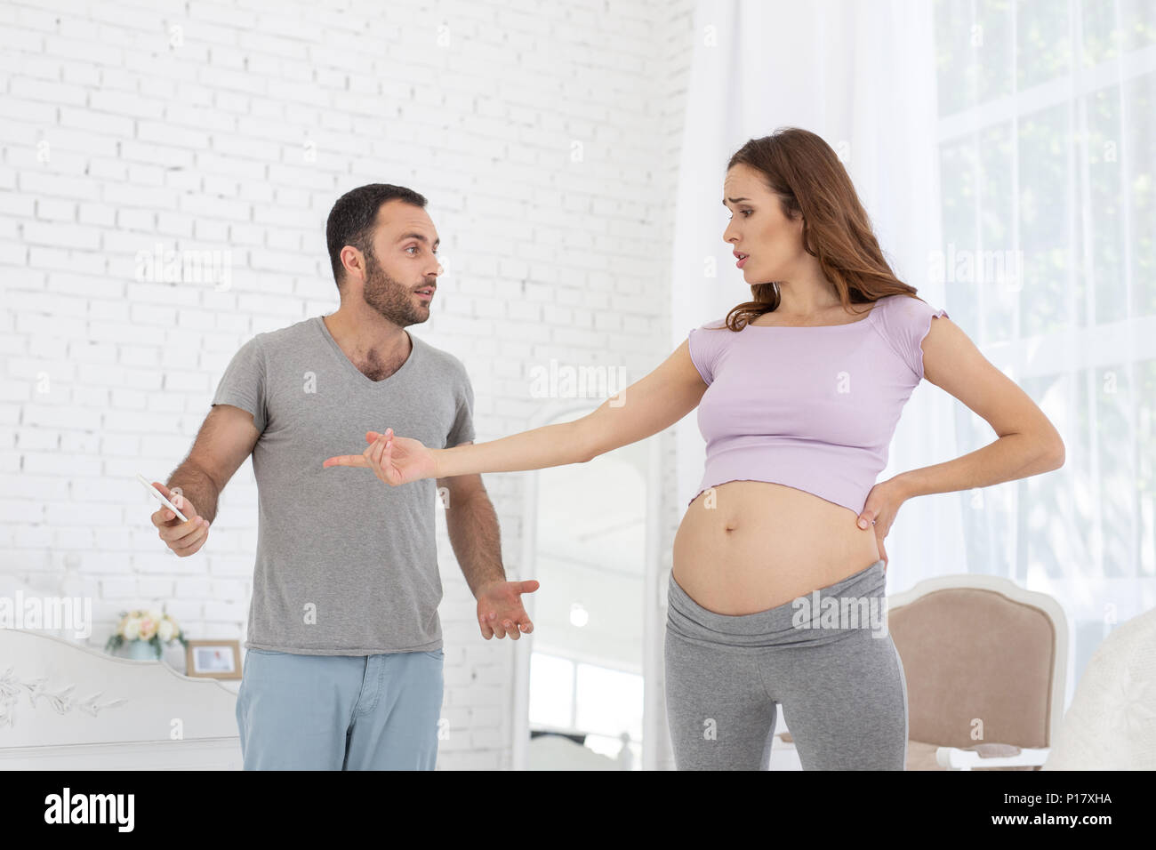 Grumpy man and pregnant woman fighting Stock Photo - Alamy