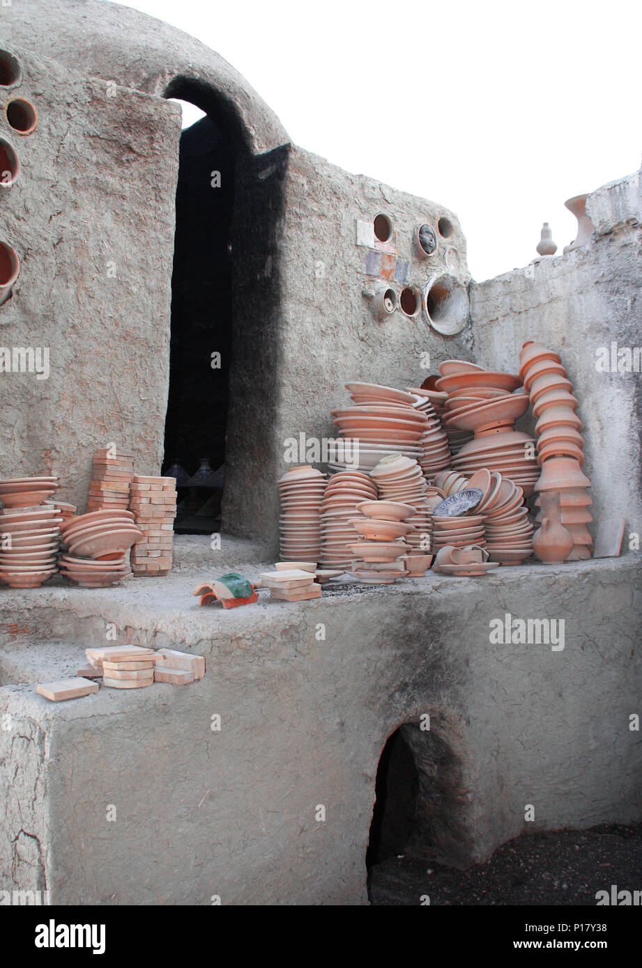 Preparing clay pottery for firing in adobe furnace. Traditional ...