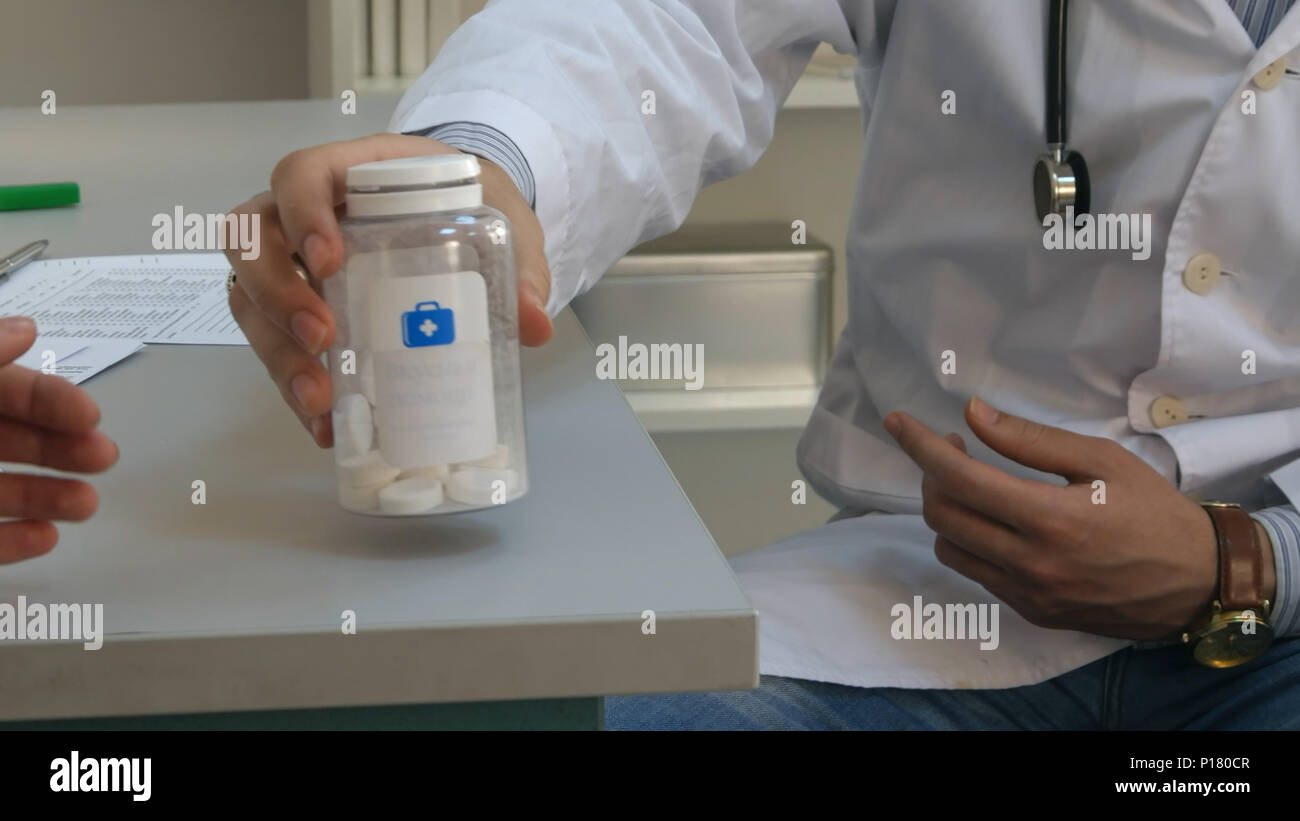Doctor giving pills to patient in exchange of money Stock Photo - Alamy