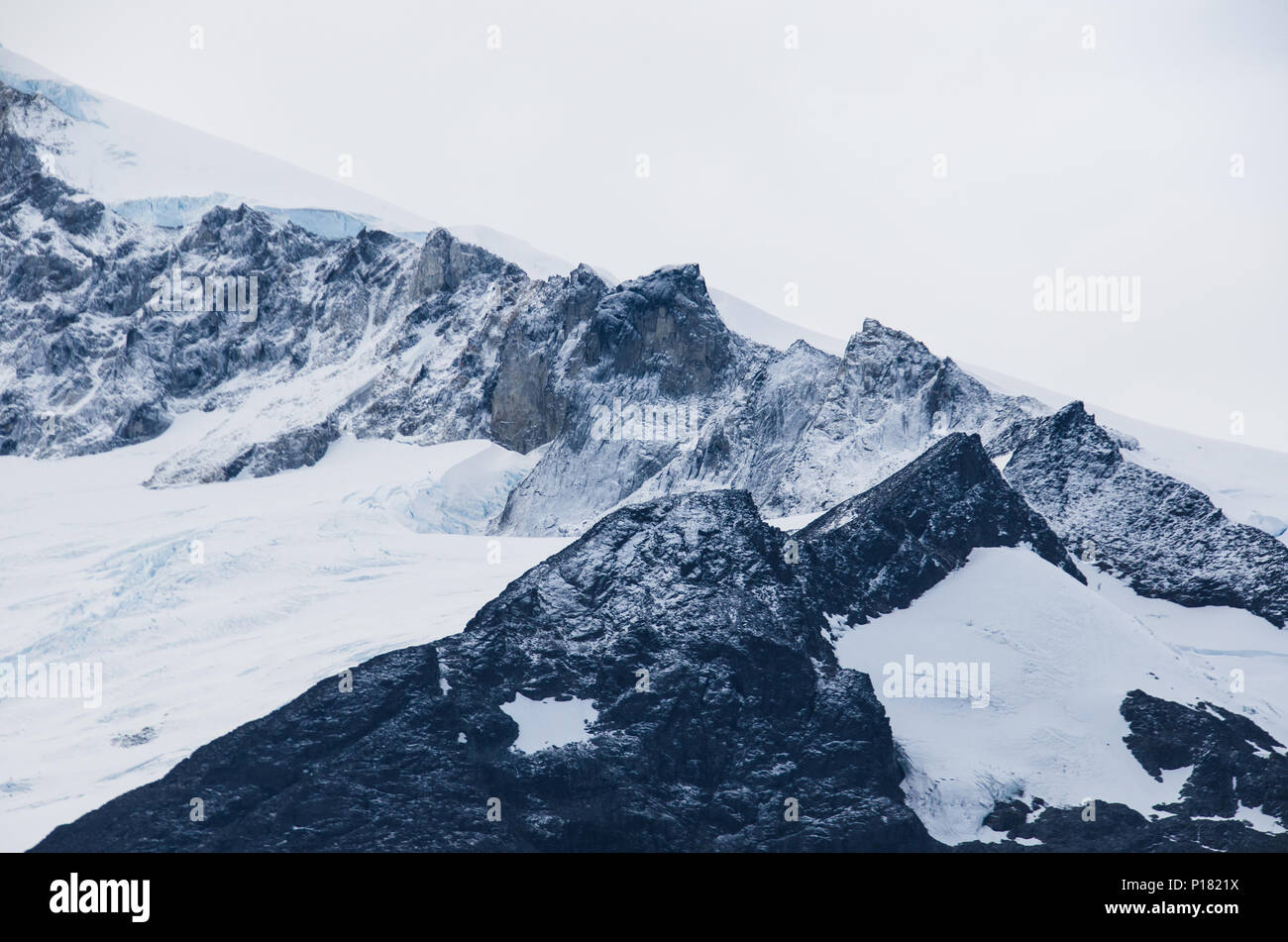 Snowy mountain ridge with rocky outcrop. Glacier Alley mountains along ...