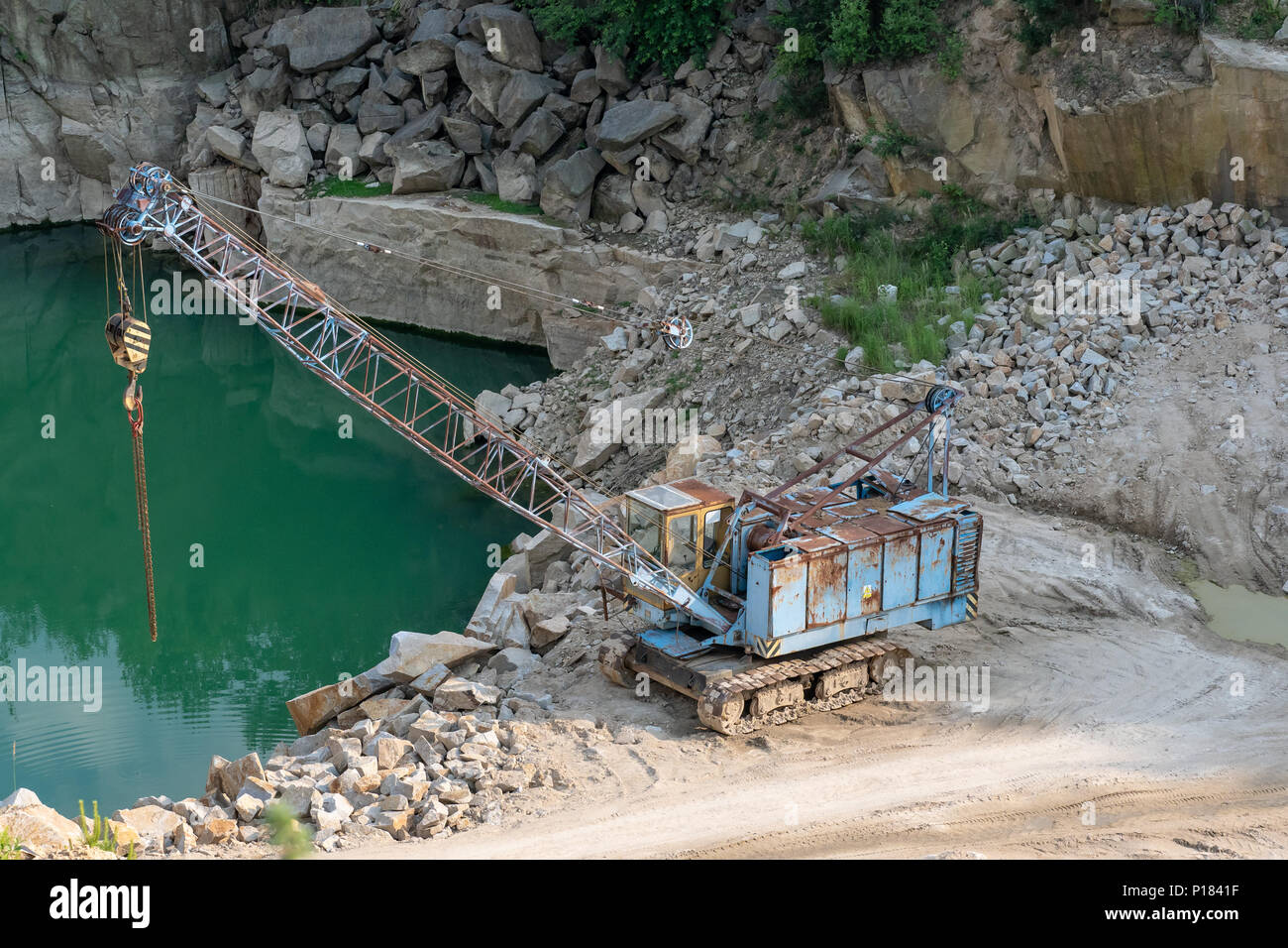 Mining in the granite quarry. Working mining machine - old crane ...