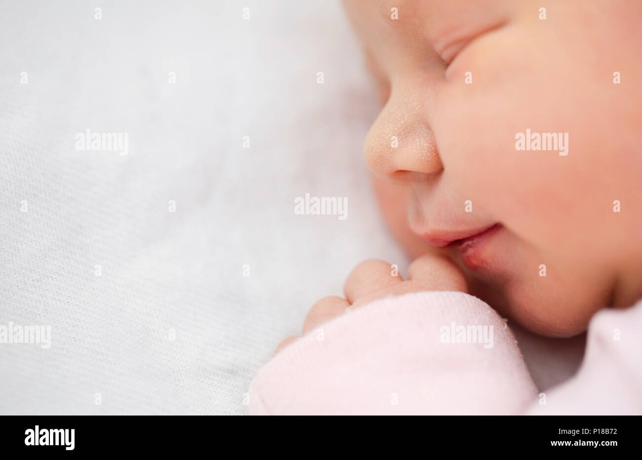 Closeup of newborn baby girl. Beautiful one day old girl smiling in her ...