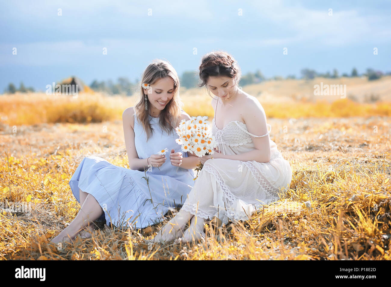 Two beautiful girls in dresses in autumn field have fun Stock Photo - Alamy