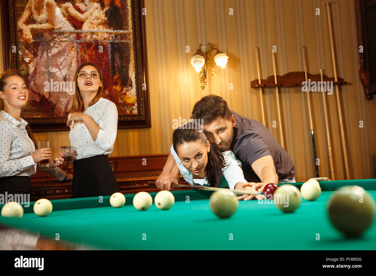Young men and women playing billiards at office after work Stock Photo ...