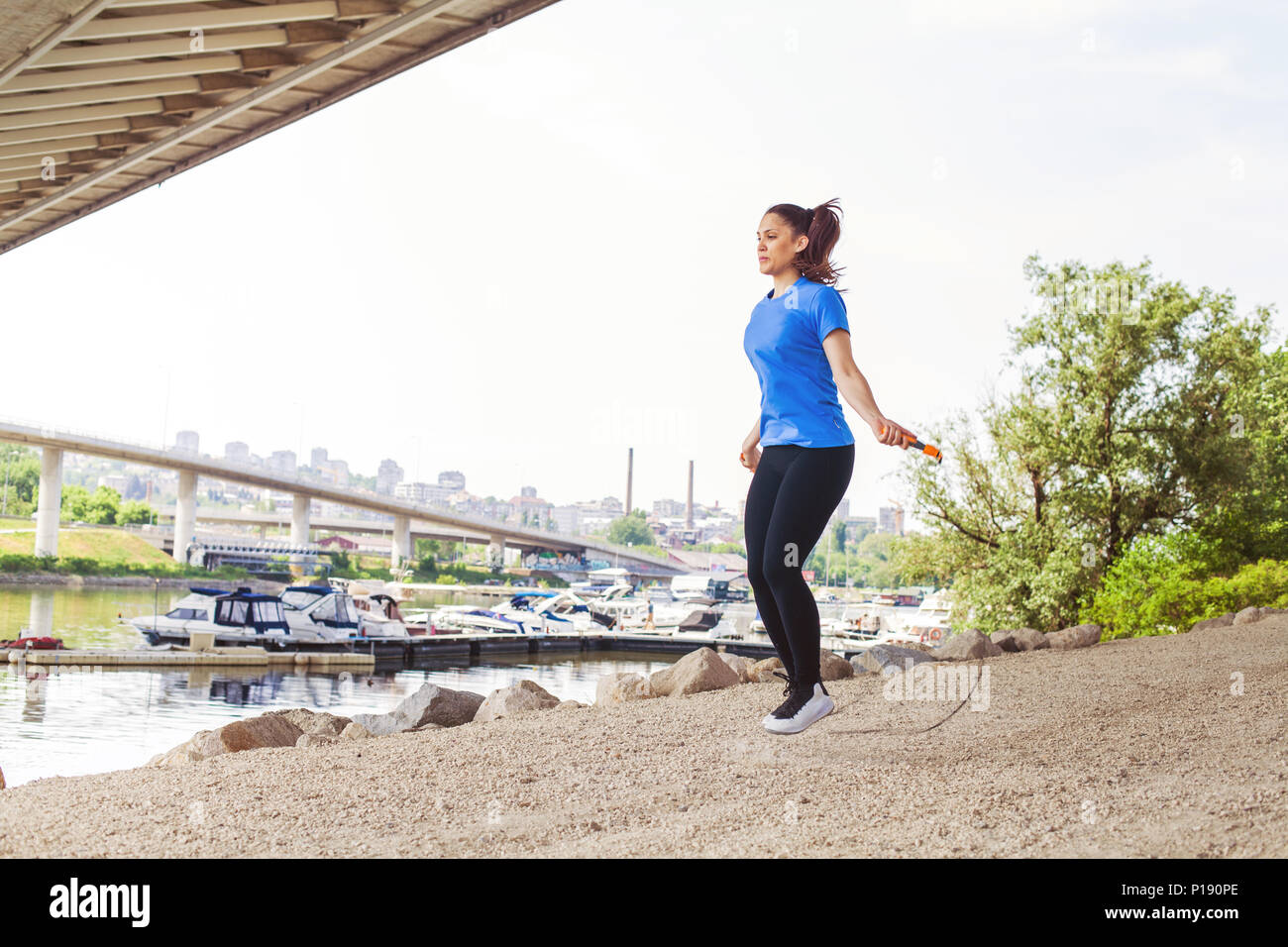 Sporty young woman exercise jumping rope, fitness training outdoor ...