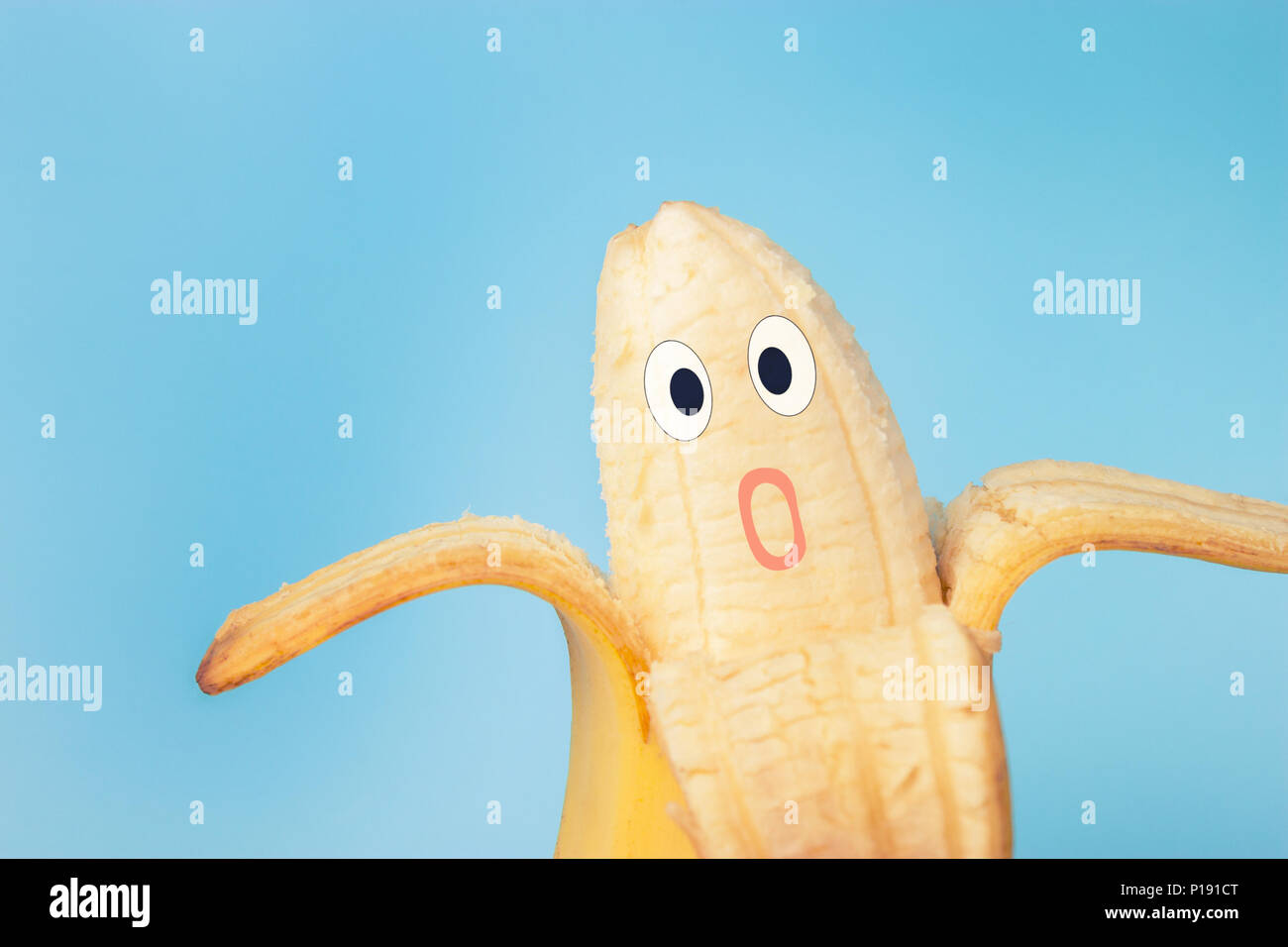 scared banana on blue background. half peele Stock Photo - Alamy
