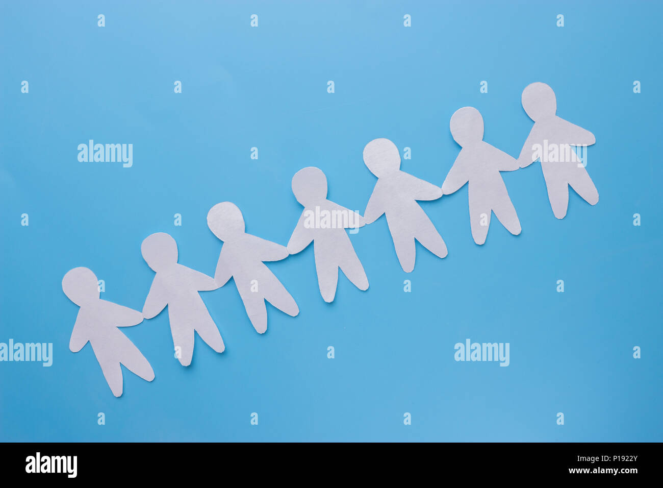 Paper people on the blue background. together possible Stock Photo - Alamy