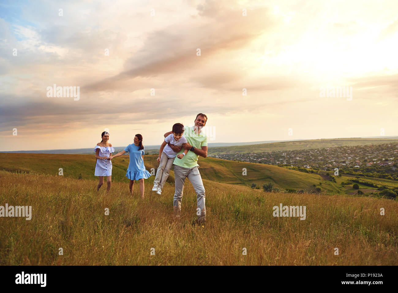 A family is having fun walking in the sunset Stock Photo - Alamy