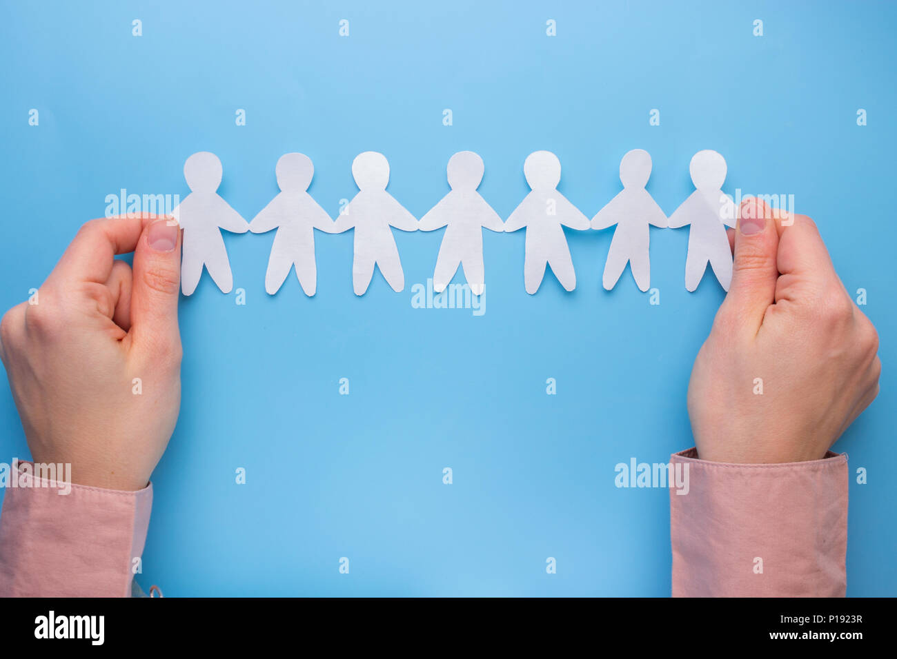 Paper people on the blue background. together possible Stock Photo - Alamy