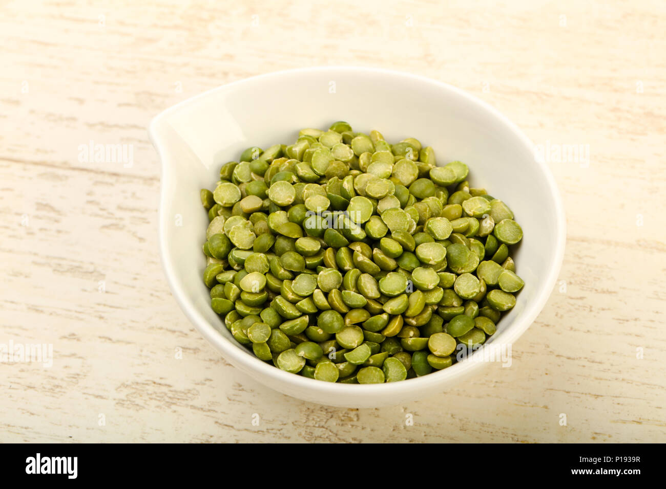 Green peas pile in the bowl over wooden background Stock Photo - Alamy