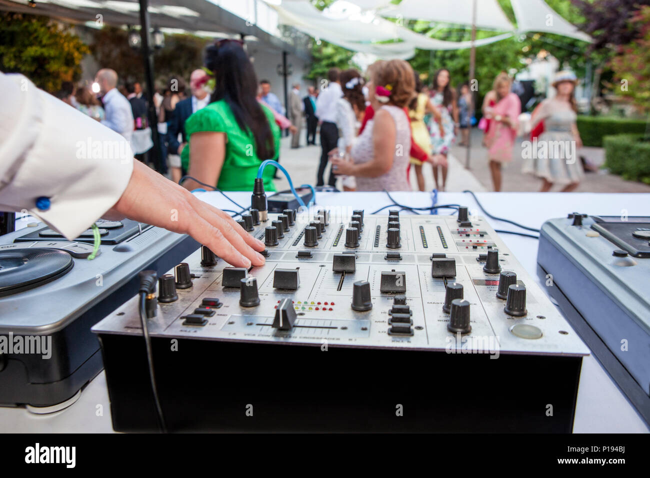 Dj hand over Soundboard at wedding party. People dancing background ...