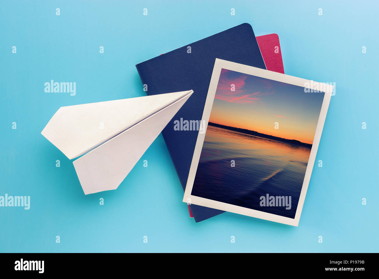Travel pictures and paper plane hanging on blue background, collage ...