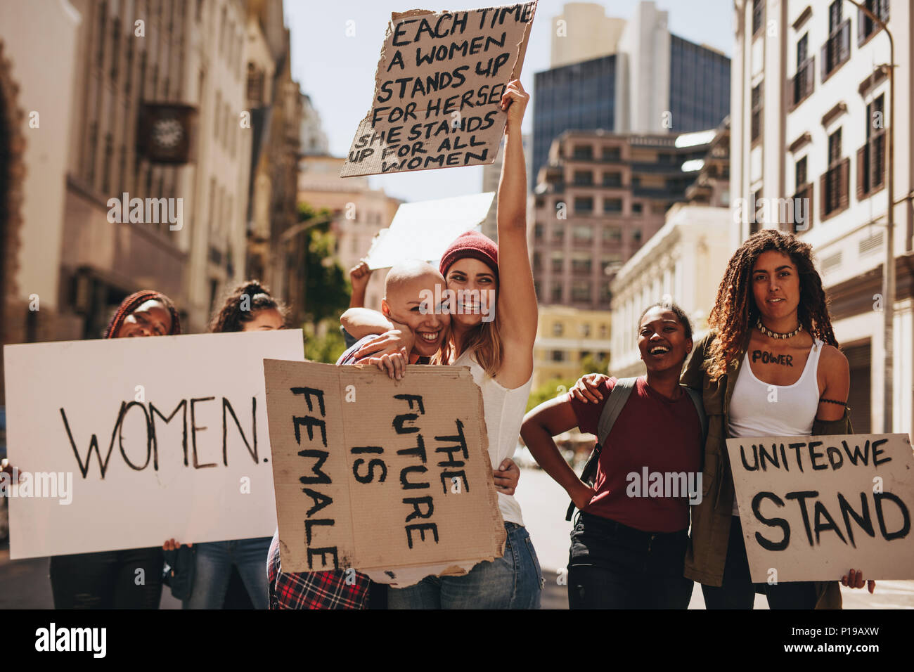 Crowd of protesters hold signs and rally on road. Group of women ...