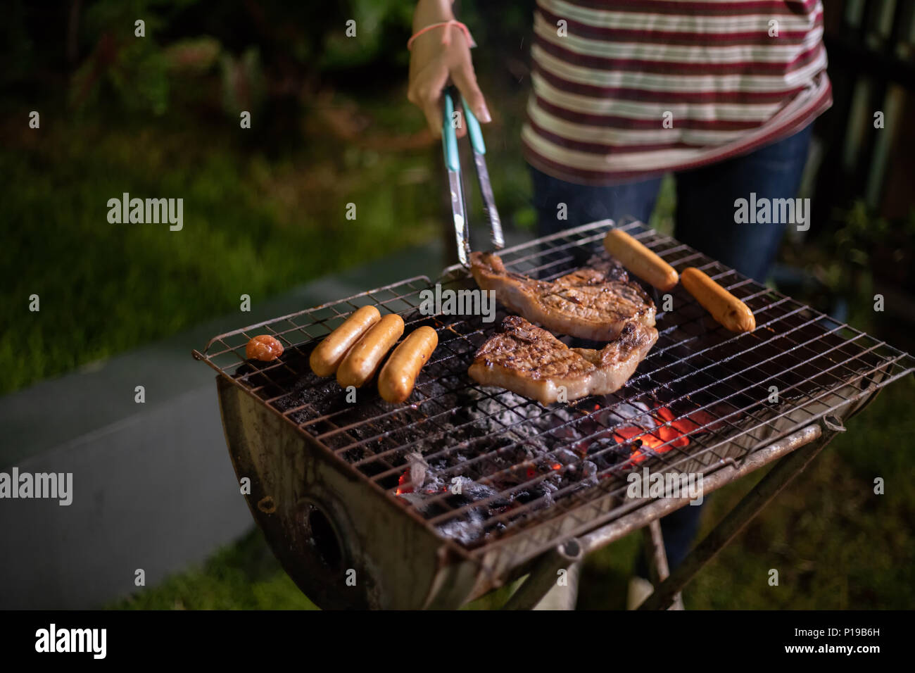 Asian group of friends having outdoor garden barbecue laughing with ...