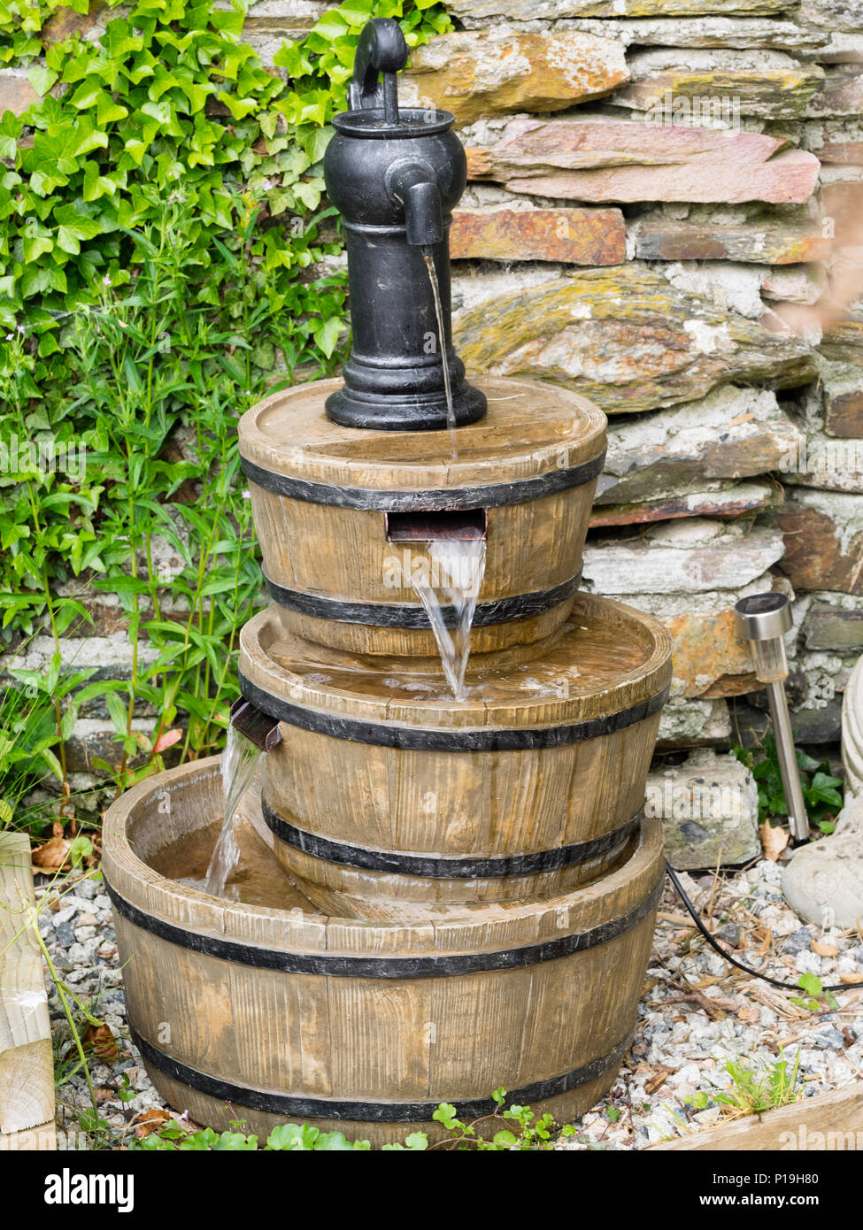 Garden water feature arranged as three barrels with pump on top Stock ...