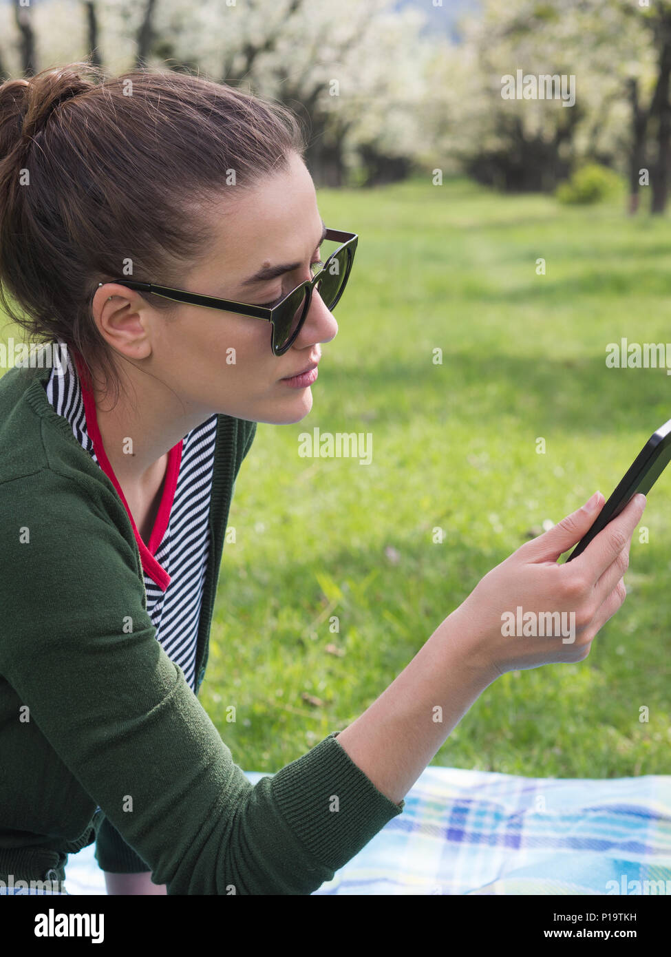 Portrait of a young beautiful woman texting on her smart phone while ...