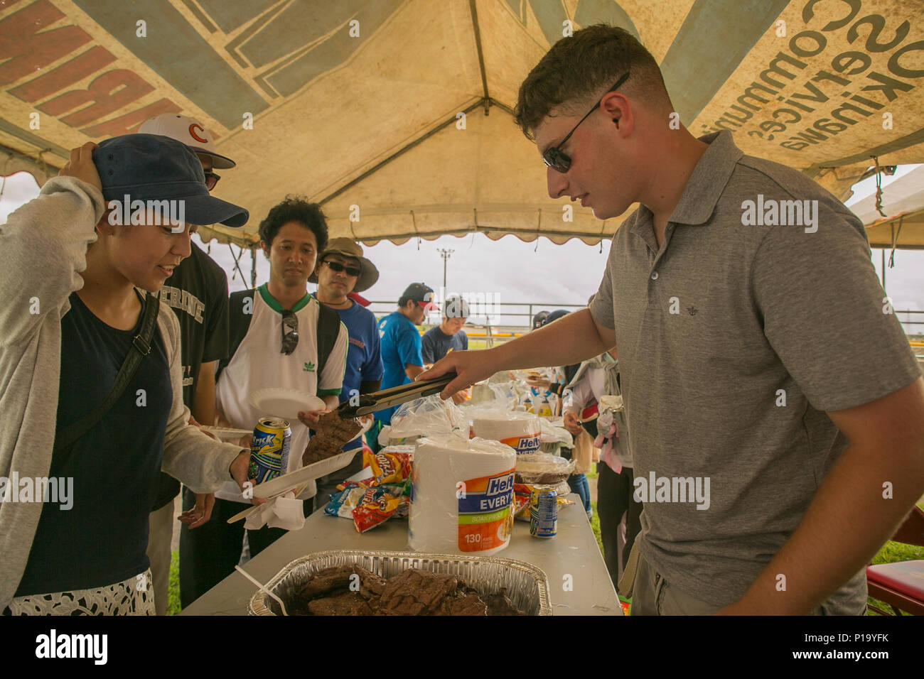 U.S. Marine Corps Cpl. Timothy Mott serves steaks to Okinawan ...
