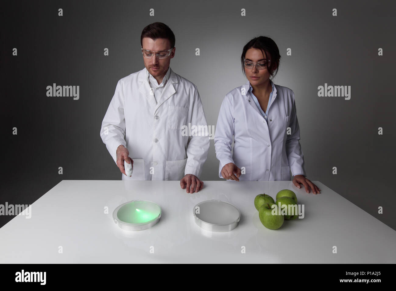 Two scientists in laboratory doing futuristic research experiments with ...