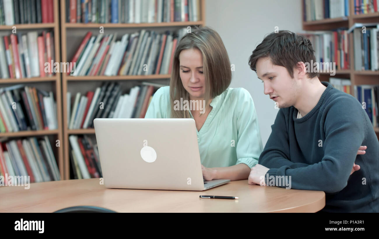 Two students studying together using laptop Stock Photo - Alamy