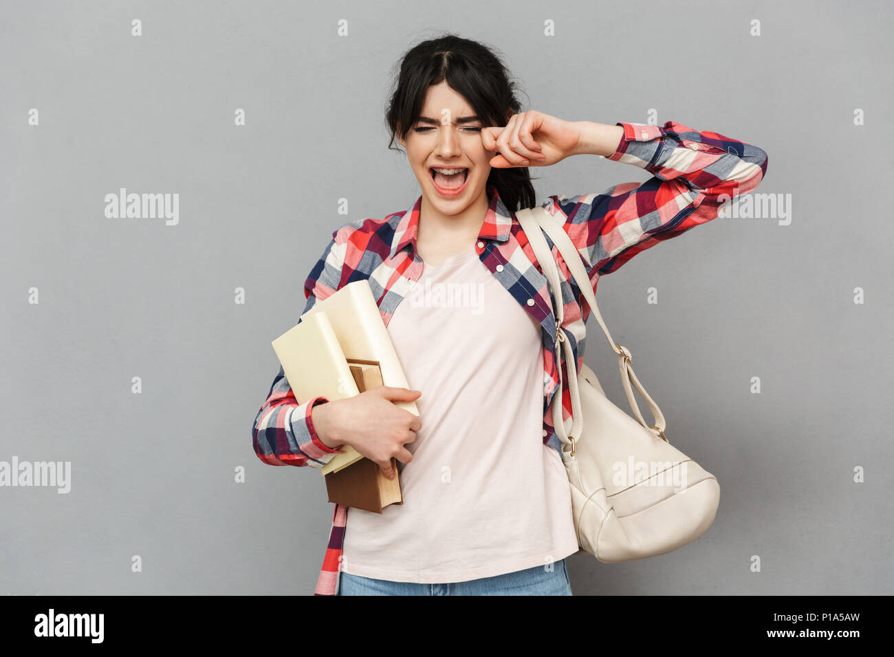 Image of sad displeased young lady student standing isolated over grey ...