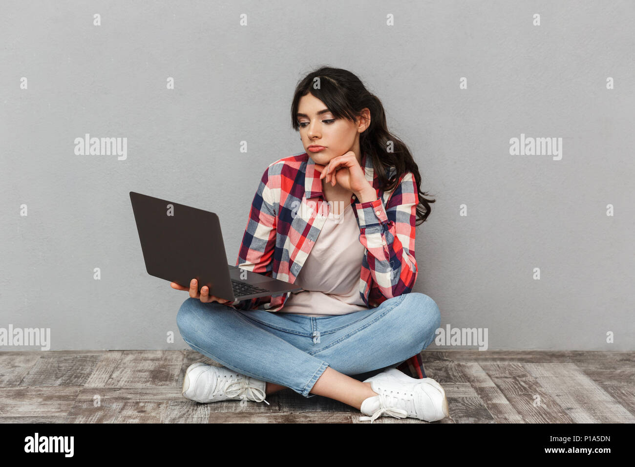Image of sad displeased young lady student isolated over grey ...