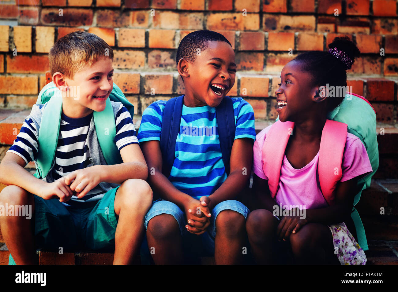 Happy children sitting on steps Stock Photo - Alamy