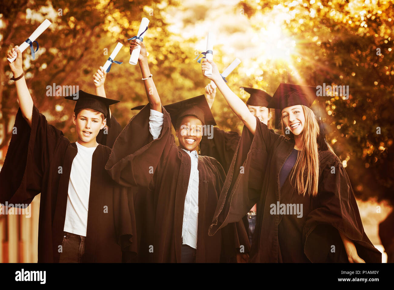 Portrait of graduate school kids standing with degree scroll in campus ...
