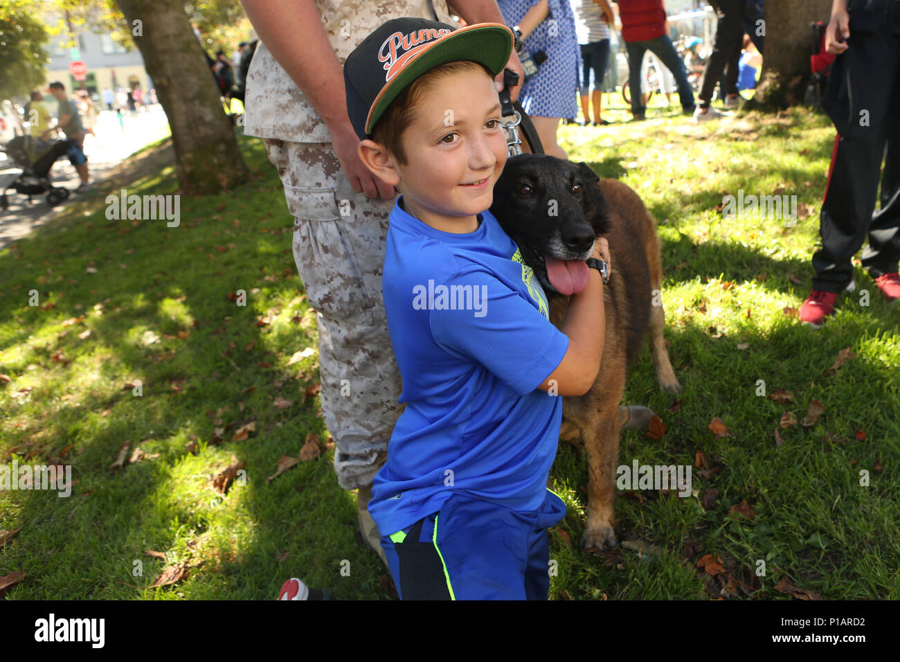 A child poses with U.S. Marine Corps military working dog Pascal at the ...