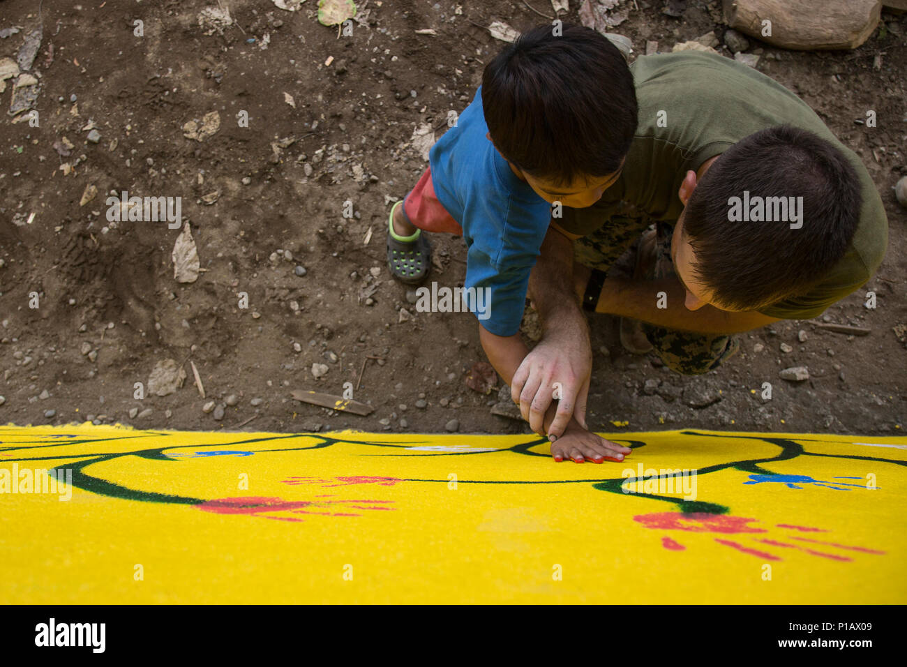 U.S. Marine Lance Cpl. Justin Blecha helps a student of the San Vicente ...
