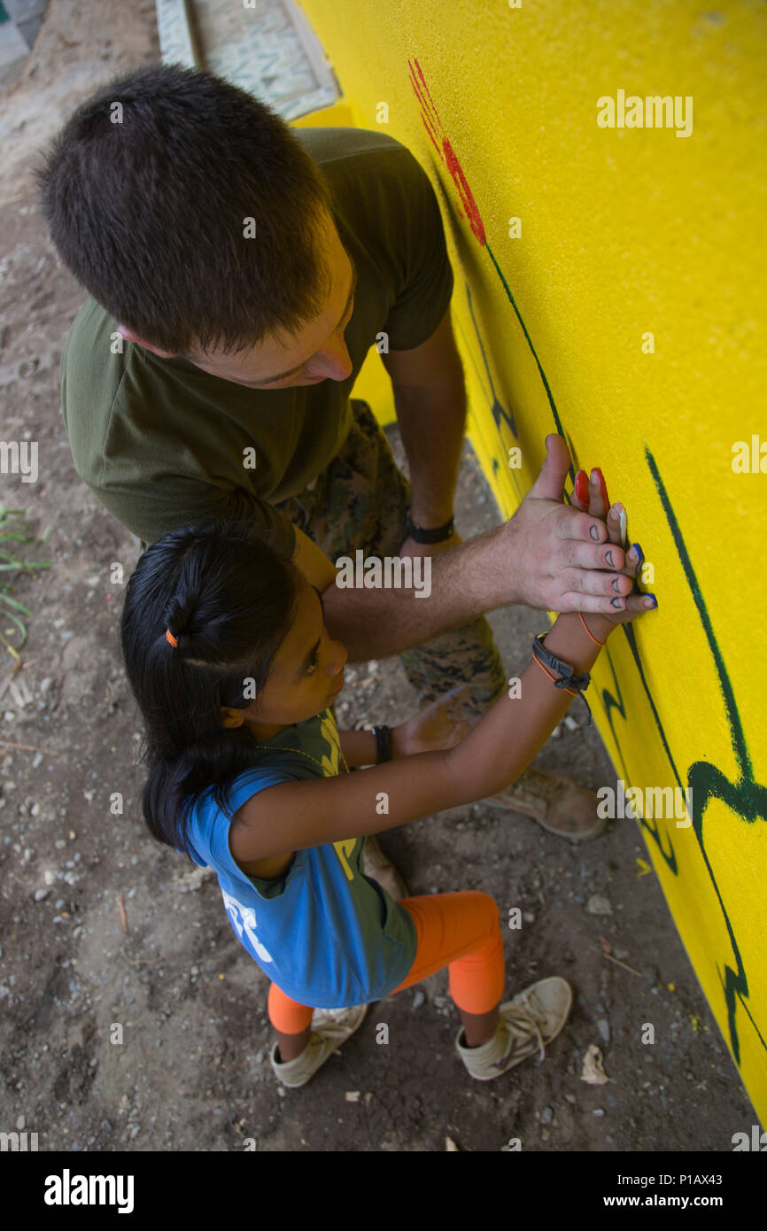 U.S. Marine Lance Cpl. Justin Blecha helps a student of the San Vicente ...