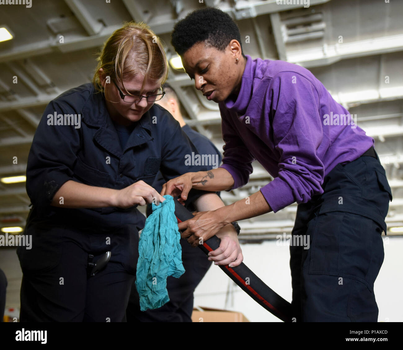 Sailors aboard the aircraft carrier USS Nimitz (CVN-68) connect a lube ...